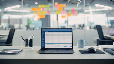 현대 크리에이티브 오피스의 책상 위에 서 있는 금융 분석 스프레드시트 응용 프로그램노트북 컴퓨터 다채로운 계획 노트와 배경 유리