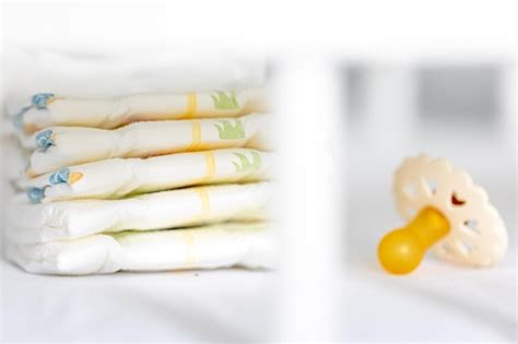 침대 근접 촬영에서 아기 젖꼭지와 기저귀 무료 사진