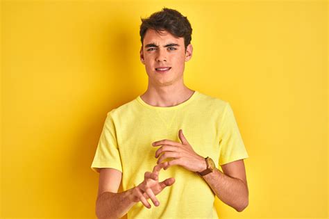 고립 된 배경 혐오 표정 위에 노란색 티셔츠를 입고 십대 소년 혐오 스러운 반응 때문에 혐오 얼굴을 하고 불쾌 하 고 두려운 얼굴 손을 들고 성가신 개념 T 셔츠에 대한