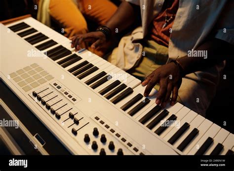 Person Playing Keyboard With Hands On Keyboard And Adjustments On Midi