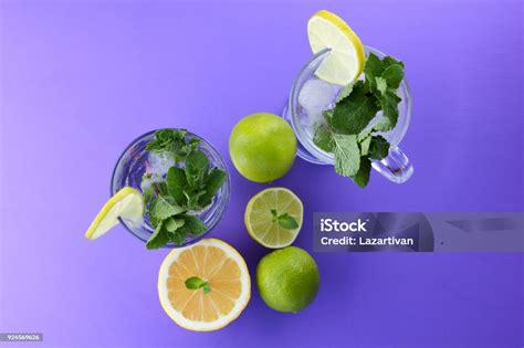 자외선 배경 민트 레몬 및 석 회 여름 휴식을 위한 청량 음료 자주색 배경 팝 아트 음료 반 레몬과 라임 미니 칵테일 칵테일 모 히 토 감귤류 과일에 대한 스톡 사진 및
