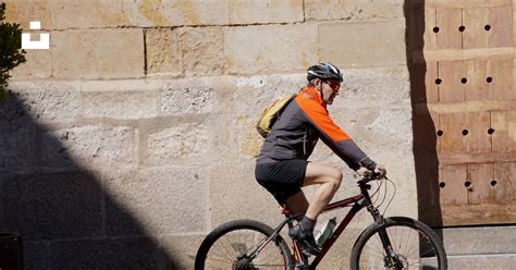 노란색과 검은색 재킷을 입은 남자가 검은색과 빨간색 자전거를 타고 있다 사진 Unsplash의 무료 스페인 이미지