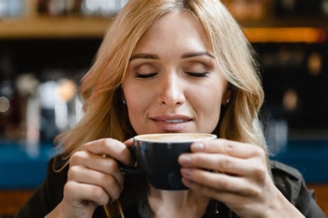 레스토랑 카페에서 아침 식사 워크 브레이크 브런치를하면서 냄새가 나는 따뜻한 음료 커피 차의 향기를 즐기는 예쁜 백인 젊은 여성 학생 프리랜서의 클로즈업 샷 30 34세에