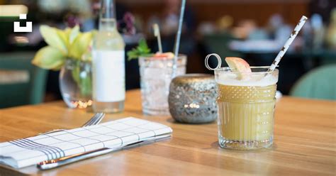 포크 옆의 유리에 채워진 액체와 테이블 나이프는 테이블에 병 근처에 있습니다 사진 Unsplash의 무료 음식 이미지