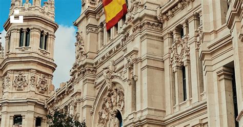 흰색 건물에 매달려 있는 노란색과 빨간색 깃발 사진 Unsplash의 무료 스페인 이미지