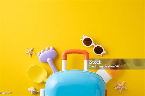 밝은 노란색 배경에 여행 가방 선글라스 장난감 자외선 차단제가 특징인 다채로운 어린이 여행 필수품으로 재미있는 여름 분위기와 해변 휴가를 즐길 수 있습니다 0명에 대한 스톡