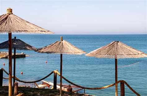 바다 지중해 해변에서 외로운 위커 태양 우산 천연 대나무 우산 및 오션 비치에서 여름 우산 양산 푸른 물과 하늘에 대 한 큰 밀 짚 비치 파라솔 휴가 여행입니다 0명에 대한