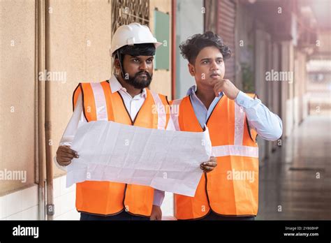 A Civil Engineer And Electrical Engineer Are Focused On Reviewing Construction Details Project