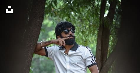 흰색 크루넥 티셔츠와 파란색 데님 청바지를 입은 남자가 낮에 나무 옆에 서 있다 사진 Unsplash의 무료 저녁 이미지