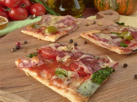 Pizza On Thin Dough With Slices Of Salami And Ham Olives And Tomatoes