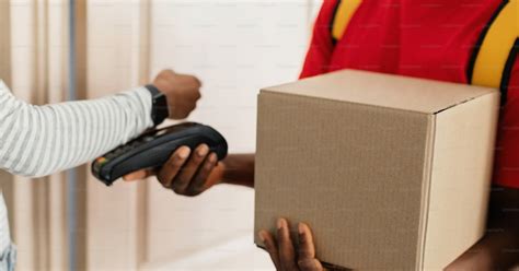 스마트워치를 사용하여 택배를 지불하는 고객 여성의 잘린 샷 집에 있는 결제 단말기에 시계를 놓기 골판지 상자에 선택적 초점 사진 Unsplash의 개념 이미지