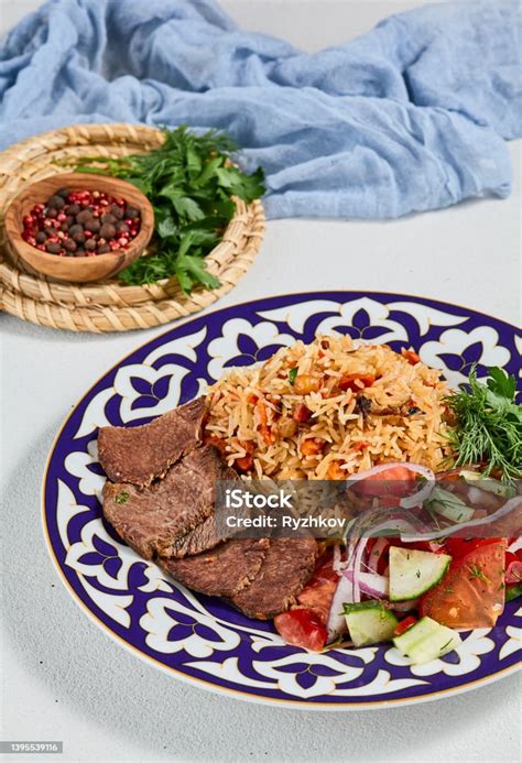 전통적인 우즈벡 음식 쇠고기와 함께 Plov 동양 요리 쌀 고기 및 향신료가있는 필라프 전통적인 우즈벡 접시에 쇠고기를 곁들인 플로브 필라프와 동양 세라믹 플레이트의 구성