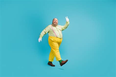 그의 전체 길이 몸 크기보기 그의 좋은 재미 펑키 기쁜 쾌활한 쾌활한 남자 산책 재미 보여주는 V기호 고립 위에 밝은 생생한