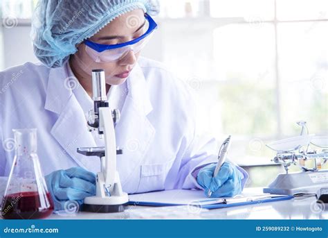 Woman Scientist Hand Write Note Information In Medical Lab Look At