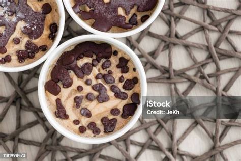 바나나와 코코넛 크림의 생 과일 아이스크림을 고리버들 식탁보에 흰 종이 컵에 천연 초콜릿 방울과 함께 닫습니다 건강한 비건 달콤한 디저트 레시피 맨 위 보기 무해한 음식 0