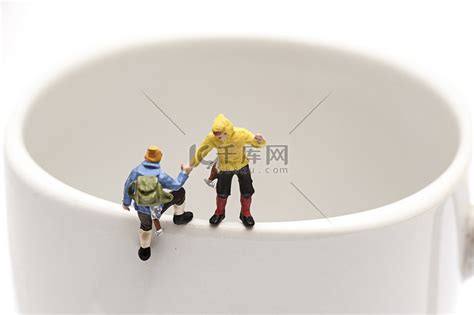 咖啡杯上的微型登山者高清摄影大图 千库网