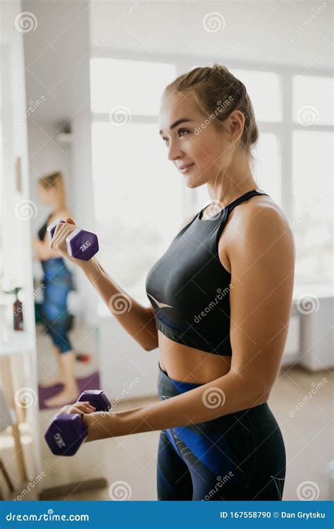 Sporty Beautiful Woman Exercising With Dumbbell At Home To Stay Fit