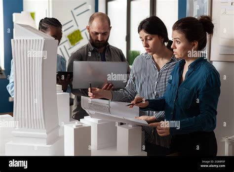 Architecture Multi Ethnic Workers Meeting At Office Analyzing Blueprint
