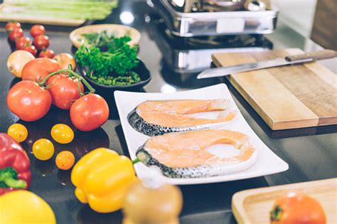 연어 필레는 요리를 위해 준비된 흰색 접시에 조각으로 자릅니다 탑 아일랜드 카운터 현대적인 주방에서 물고기에 대한 스톡 사진 및 기타 이미지 Istock