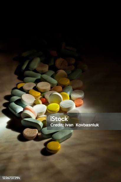 골판지 배경에 흰색 노란색 빨간색 주황색 및 파란색 알약 대조 극적인 빛과 어두운 배경에 약물 0명에 대한 스톡 사진 및 기타 이미지 Istock