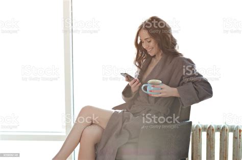 한 잔의 커피와 아침 부엌에서 스마트폰으로 어두운 작업복에 아름 다운 행복 한 여자 러시아에 대한 스톡 사진 및 기타 이미지 러시아 머그 명랑한 Istock