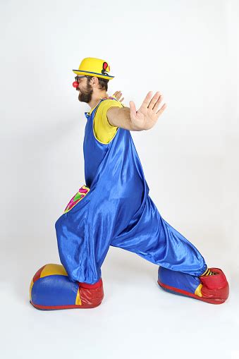 광대는 밝은 파란색과 노란색 정장 안경과 모자를 쓰고 감정적으로 노는 남자입니다 40 44세에 대한 스톡 사진 및 기타 이미지 40 44세 Theatrical