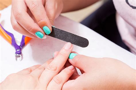 손톱 파일 미용사에 의해 매니큐어를 받는 네일 살롱에서 여자의 근접 촬영 샷 여자 손톱 매니큐어를 받고 미용사는 고객에 게 손톱을 파일 가꿔주기에 대한 스톡 사진 및 기타