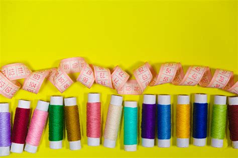 바느질을 위한 여러 가지 색상의 스레드 세트와 노란색 배경의 측정 테이프 상단 보기입니다 개인 장식품에 대한 스톡 사진 및 기타 이미지 Istock