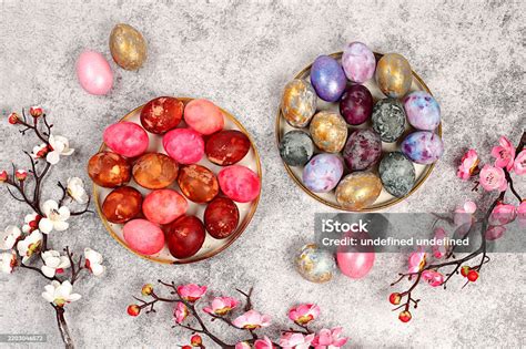 부활절 축하 개념 양파 껍질 히비스커스 차 분홍색 말차로 그린 대리석 부활절 달걀 벚꽃 가지가 있는 콘크리트 배경 수제 부활절 요리에 대한 아이디어 4월에 대한 스톡 사진