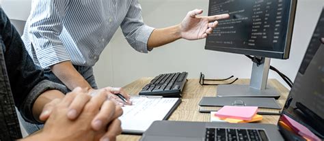 두 명의 전문 프로그래머가 회사에서 데스크톱 컴퓨터에서 개발 중인 소프트웨어 코드 및 데이터 코드 입력 Html Php 및 자바스크립트로 프로그래밍하는 소프트웨어에서 웹