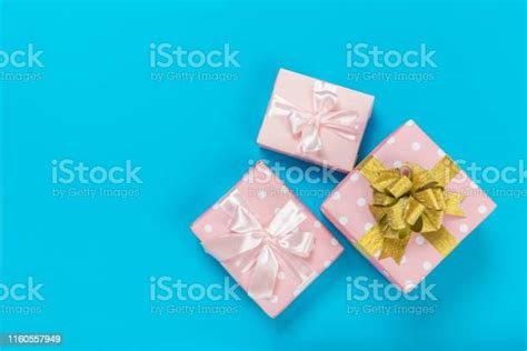 파란색 표면에 금색과 분홍색 리본종이에 싸여 아름다운 선물 상자 복사 공간이 있는 맨 위 뷰입니다 갈색에 대한 스톡 사진 및