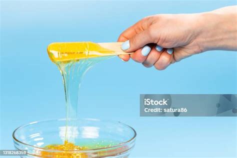 파란색 배경에 설탕을 넣기 위해 액체 노란색 페이스트를 들고있는 여성의 손 탈모 및 제모 개념 Waxing에 대한 스톡 사진 및 기타 이미지 Istock