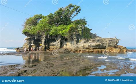 Tanah Lot Water Temple In Bali During Low Tide With Blue Sky And Waves