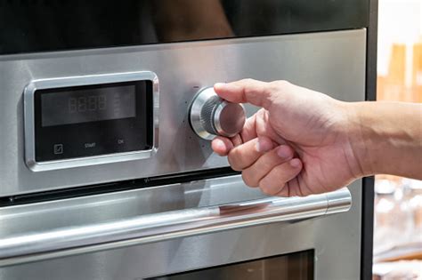 현대 부엌에서 오븐의 온도 다이얼 손잡이를 돌리는 남성 가정용 주방용 조리기구 가사 집안일에 대한 스톡 사진 및 기타 이미지 가사 집안일 가정 생활 가정 주방