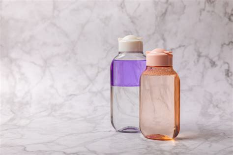 대리석 배경에 미셀라 클렌징 워터와 면봉 욕실에 있는 페이셜 클렌징 또는 메이크업 리무버 화장품 병 스킨 케어 개념 메이크업과 피부 피지의 얼굴을 정화합니다 깨끗한에 대한