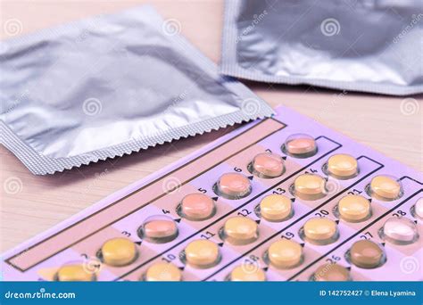 Birth Control Pills And Condoms In Package On Light Backgroundconcept
