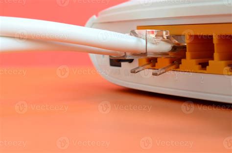 The Internet Cable Plugs Are Connected To The Internet Router Which Lies On A Bright Orange