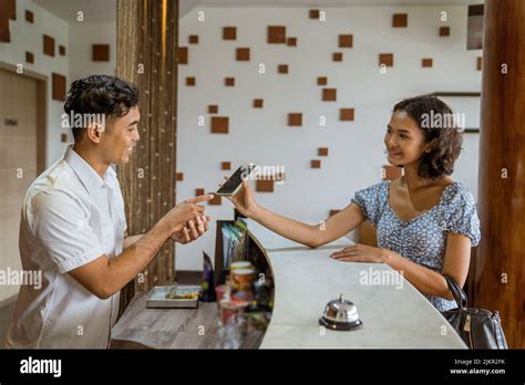 Female Guest Showing Smartphone At Receptionist For Proof Of Booking Stock Photo Alamy
