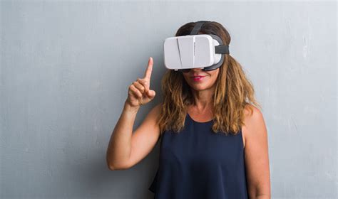 중세 스페인 여자 회색 그런 지 서 가상 현실 안경을 착용 아이디어 놀된 벽 또는 행복 한 얼굴 넘버 원 가리키는 손가락 질문 3차원 형태에 대한 스톡 사진 및 기타 이미지