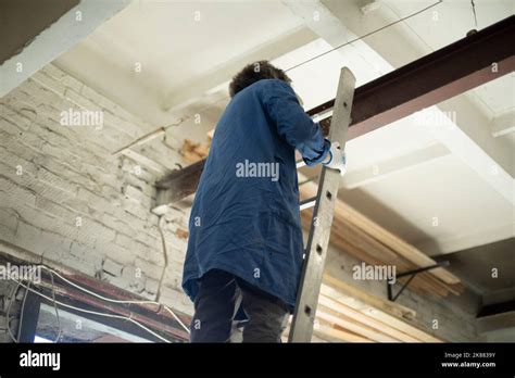 Guy Is Standing On Stairs Worker Hangs Chain On Steel Beam