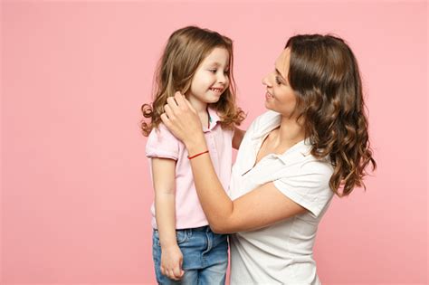 가벼운 옷에 여자는 귀여운 아이 아기 소녀와 재미가 있다 어머니 작은 아이 딸 파스텔 분홍색 벽 배경 스튜디오 초상화에 고립 어머니의 날 사랑 가족 부모가 어린 시절의 개념
