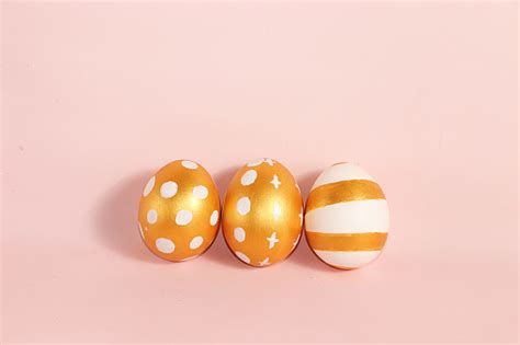 분홍색 배경에 황금 부활절 달걀을 장식 최소한의 휴가 개념 행복한 부활절 배경입니다 집에서 계란의 창조적 인 그림 착색을위한 간단한 도면의 아이디어 4월에 대한 스톡 사진