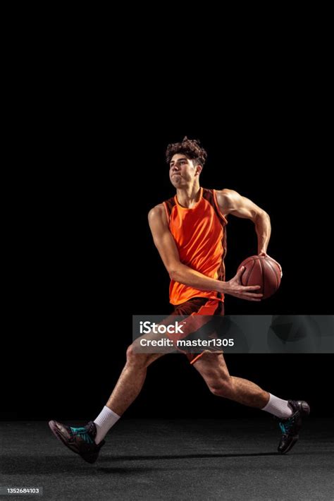 어두운 스튜디오 배경에 고립 된 농구 선수 훈련의 전체 길이 초상화 키가 큰 근육질 운동 선수가 공을 가지고 점프합니다 18 19세에 대한 스톡 사진 및 기타 이미지