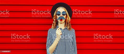 빨간 배경에 막대기에 콧수염을 보여주는 재미 있고 쾌활한 젊은 여자의 초상화 사람들에 대한 스톡 사진 및 기타 이미지 사람들 콧수염 기이함 Istock