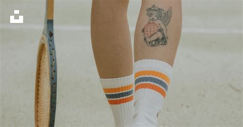 오른쪽 다리에 검은색과 빨간색 별 문신이 있는 흰색 양말과 흰색 양말을 신은 사람 사진 Unsplash의 무료 테니스 이미지