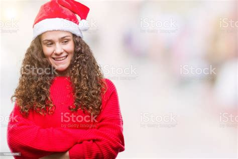 젊은 갈색 머리 여자에 크리스마스 모자를 쓰고 고립 배경 무기는 카메라 보고 넘어와 함께 웃 고 행복 한 얼굴 긍정적인 사람입니다 갈색 머리에 대한 스톡 사진 및 기타