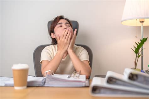 일하는 동안 피곤하고 졸린 아시아 여성 사무실에서 두통을 앓는 여성 사업가 늦은 밤 집에서 문서 폴더 더미를 들고 지친 여성