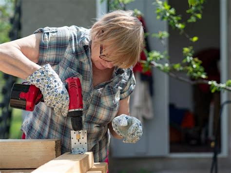 Premium Photo Senior Caucasian Woman Assembles A Wooden Frame Of