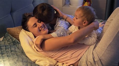 잠옷을 입고 침대에 누워 잠자리에 들기 전에 아이들을 껴안고 있는 행복한 웃는 여자 18 23 개월에 대한 스톡 사진 및 기타 이미지 18 23 개월 3 명 30