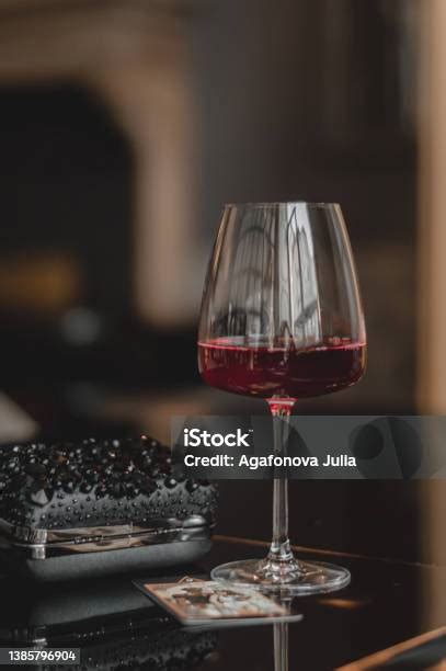 빨간 와인 한 잔이 여성 가방 옆에 있는 어두운 테이블에 서 있습니다 음료 카페 레스토랑 여유 공간을위한 아름다운 안경 0명에 대한 스톡 사진 및 기타 이미지 Istock